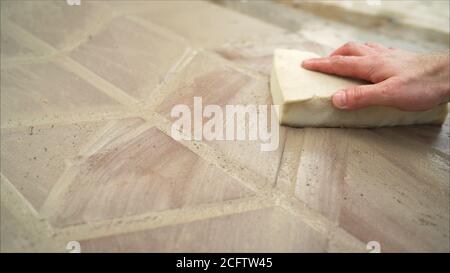 poorly laid pavement tiles on a walkway in the park. Worker makes ...