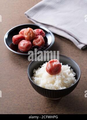 Japanese pickled plum and freshly cooked rice with one pickled plum ...