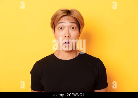 Close-up of surprised, speechless asian guy, drop jaw and raising ...