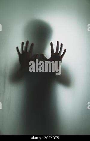 Horror ghost woman behind the matte glass in black and white. Halloween ...