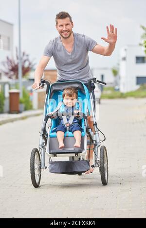 happy father with child in stroller at summer park Stock Photo - Alamy
