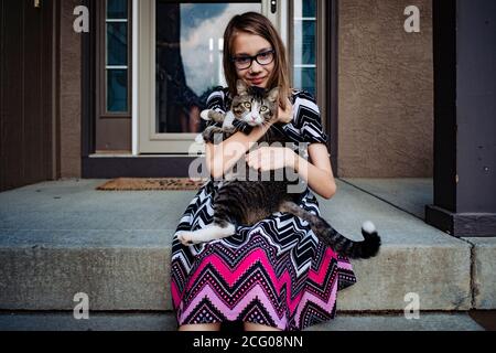 Girl holding a gray cat Stock Photo - Alamy
