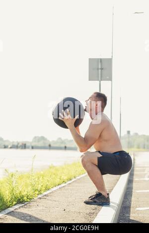 Workout bodyweight exercises using heavy weight ball Stock Photo - Alamy