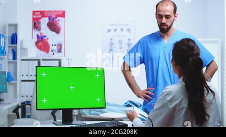 Computer with replaceable green screen in modern hospital cabinet and ...