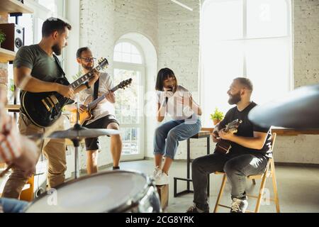 Inspiration. Musician band jamming together in art workplace with ...