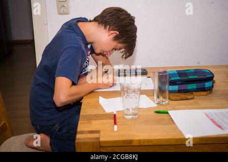 a teenager doing her homework at home after school, in Sint-Denijs ...