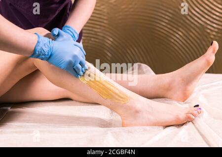 Sugaring: epilation with liquate sugar at legs Stock Photo - Alamy