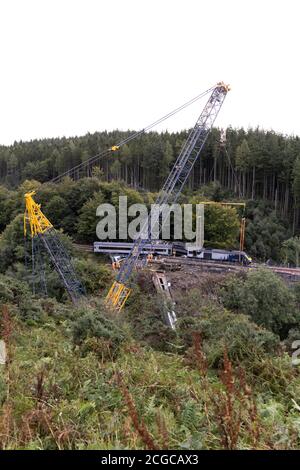 A carriage is lifted by a crane from the scene of rail crash at ...