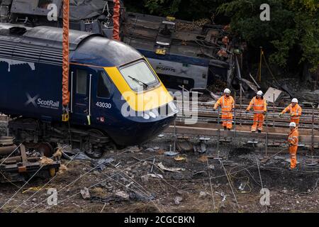 A carriage is lifted by a crane from the scene of rail crash at ...