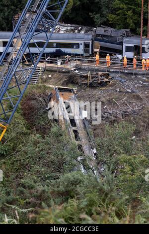A carriage is lifted by a crane from the scene of rail crash at ...