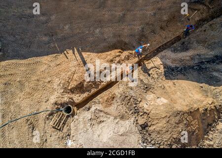 Workers lay underground cable, trench installations Stock Photo - Alamy