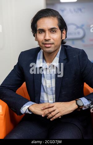Young male employee sitting in the office Stock Photo - Alamy
