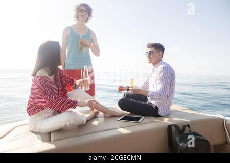 friends drinking beers in boat party. Group of people partying on yacht ...