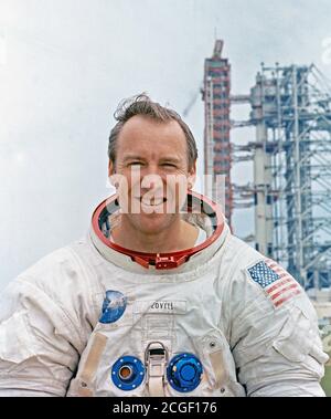 Portrait of astronaut James A. Lovell, Jr. in his space suit beside a ...