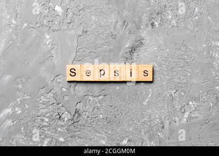 Sepsis word written on wood block. Sepsis text on cement table for your ...