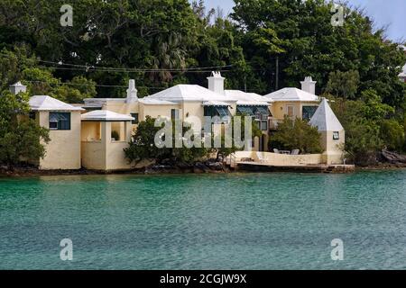 pale yellow house, waterfront, patios, concrete dock, chairs, chimneys ...
