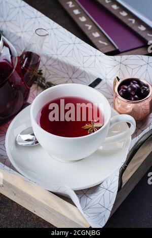 Teapot of tasty tea with cranberry on color background Stock Photo - Alamy