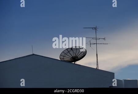 Satellite dish receivers above building roofs, communication technology ...