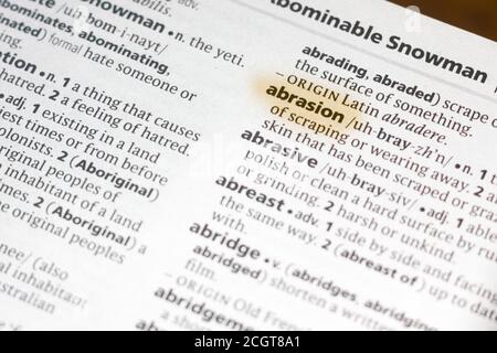 The word or phrase Abrasion in a dictionary highlighted with marker ...