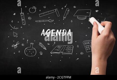 Hand drawing AGENDA inscription with white chalk on blackboard ...