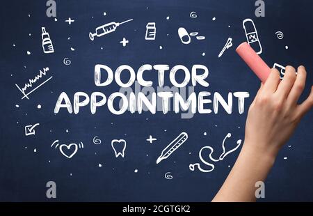 Hand drawing DOCTOR APPOINTMENT inscription with white chalk on ...