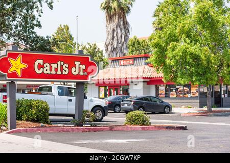 Facade of Carl's Jr fast food restaurant with two workers in orange ...