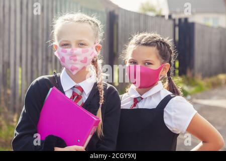 Two young primary 6 year old school children at home in school uniforms ...
