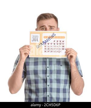Sad man holding calendar with written word QUARANTINE and inflatable ...