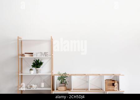 Stylish stand and rack with decor near light wall in room Stock Photo ...
