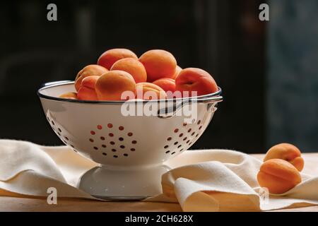 Colander with tasty ripe apricots on light background, top view Stock ...