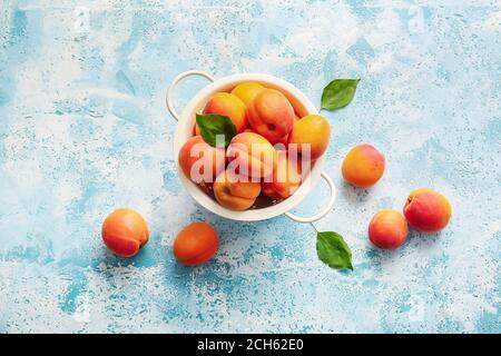 Colander with tasty ripe apricots on color background, top view Stock ...