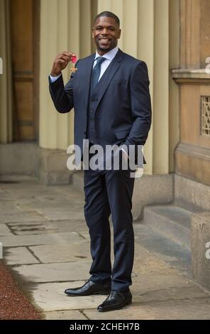 Boxer Mark Prince holds his OBE medal, awarded to him during an ...