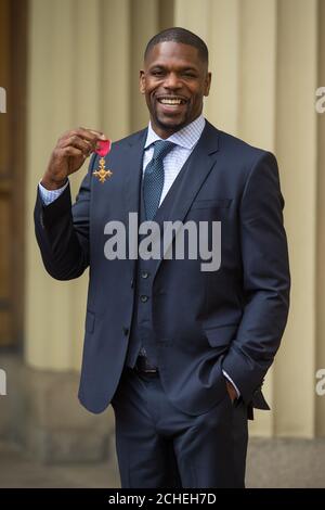 Boxer Mark Prince holds his OBE medal, awarded to him during an ...