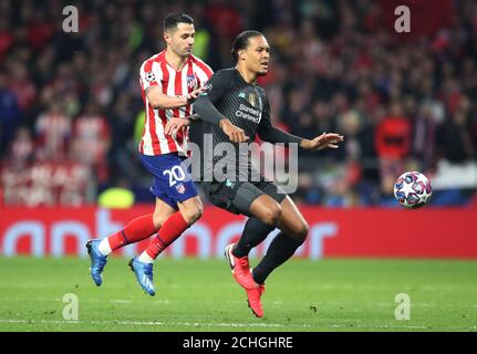 Liverpool's Virgil van Dijk holding the trophy as the open-top buses ...