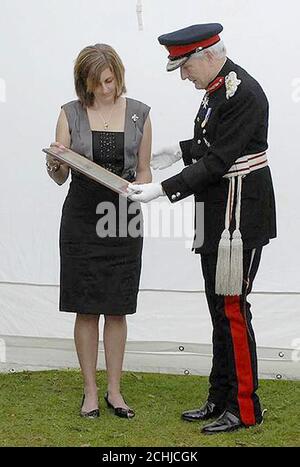 Karen Upton, the wife of Warrant Officer Sean Upton, is presented with ...