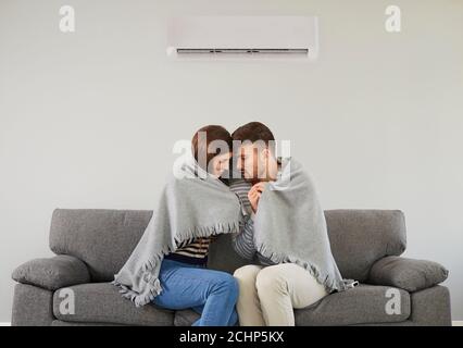 Freezing couple in cool room cuddling in plaid Stock Photo - Alamy