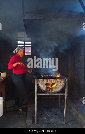 African woman cooking Shisa Nyama fire grill at market in township ...