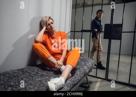 A young pretty blonde prisoner in a general regime prison is sitting in ...