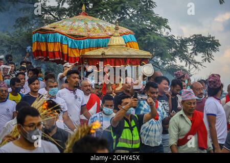 Devotees are seen carrying the rain deity Rato Machhindra Nath during a ...