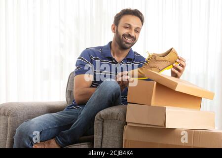 Man looking at his new shoes happily Stock Photo - Alamy