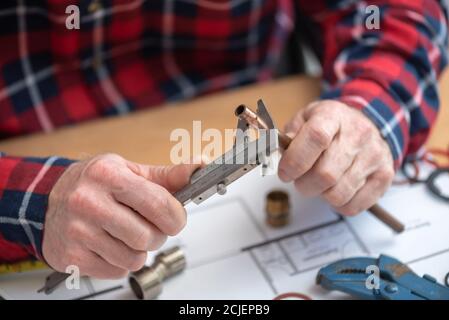 Plumber measuring a copper tube with a caliper; panoramic banner Stock ...