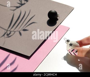 white christmas ball with palm leaf and blooming white flowers as ...