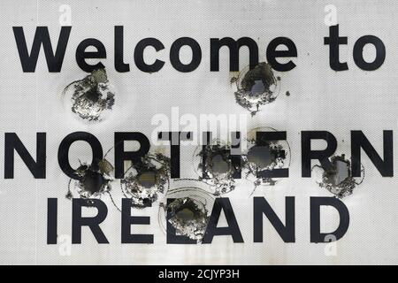 A welcome to Northern Ireland sign riddled with large bullet holes ...