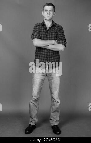 Full body of confident male with short hair looking at camera while ...