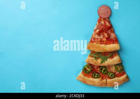 Christmas tree made of pizza slices, fir branches and balls on blue ...