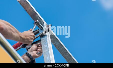 Screwing and tightening a bolt by clamp and ratchet wrench in steel ...