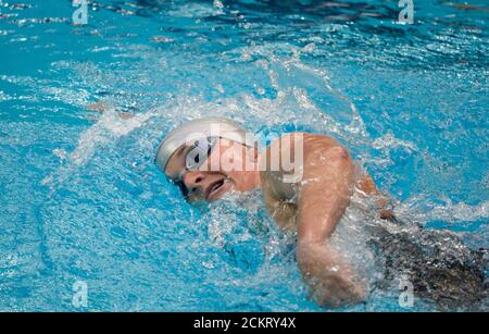 Female paralympic swimming athlete in dive position for swim race ...
