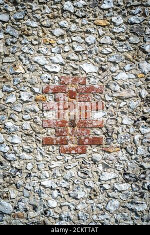 A traditional brick and flint wall with decorative copings in the ...