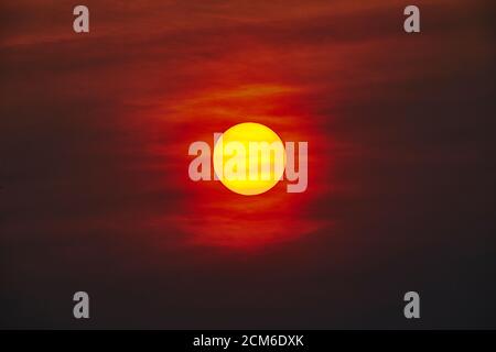 Close up of the sun setting with an overcast sky Stock Photo - Alamy