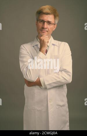 Man doctor with blond hair against gray background Stock Photo - Alamy